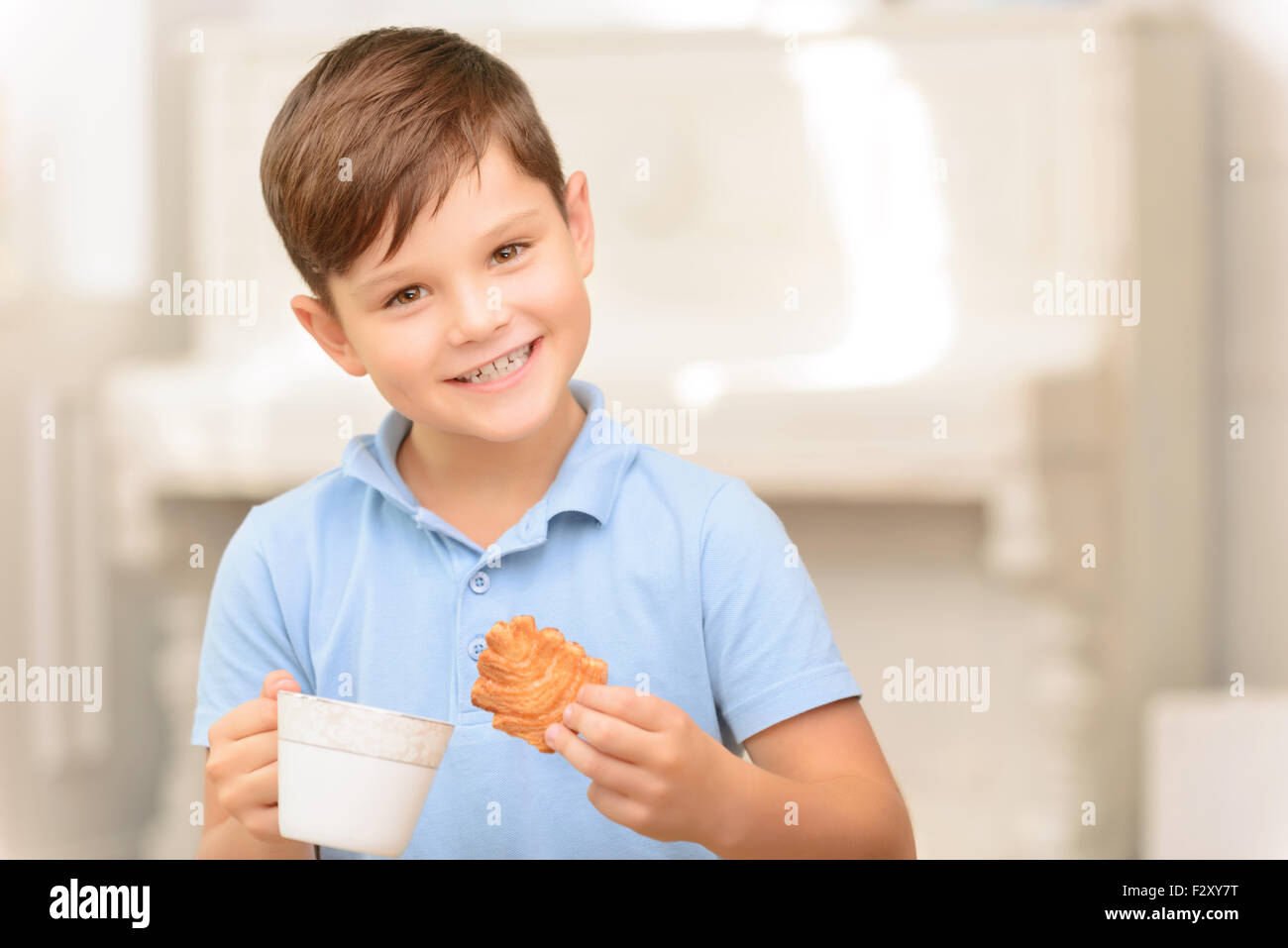 Joyful boy drinking tea Stock Photo - Alamy