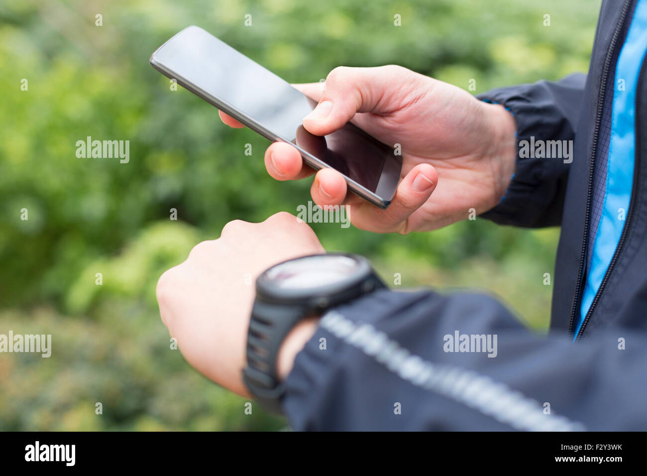 Running man with Mobile phone connected to a smart watch . Close-up ...