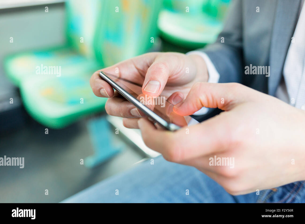 On bus man texting sms, using cell phone apps. gaming. Close-up hands ...