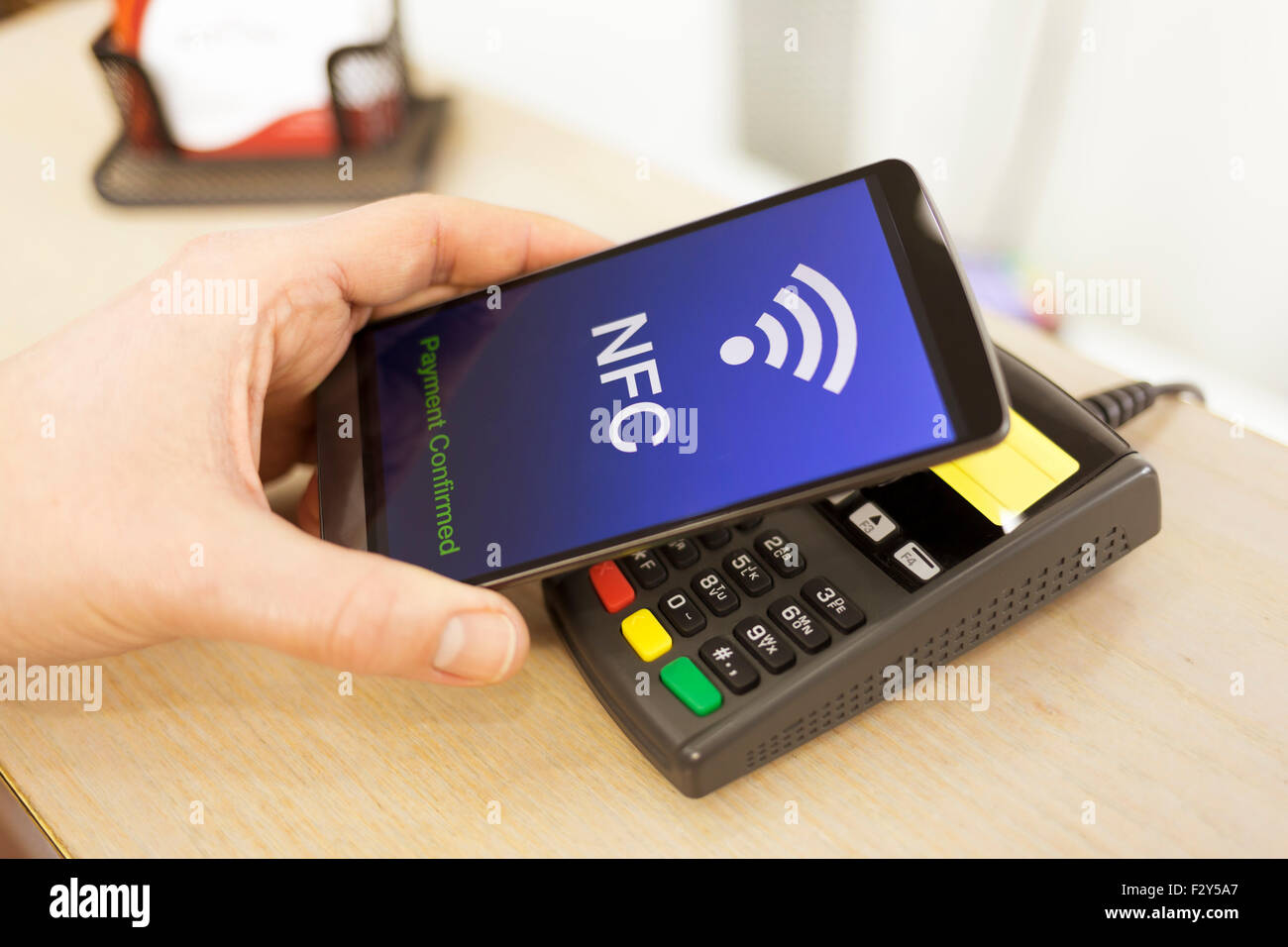 Man paying with NFC technology on mobile phone Stock Photo - Alamy