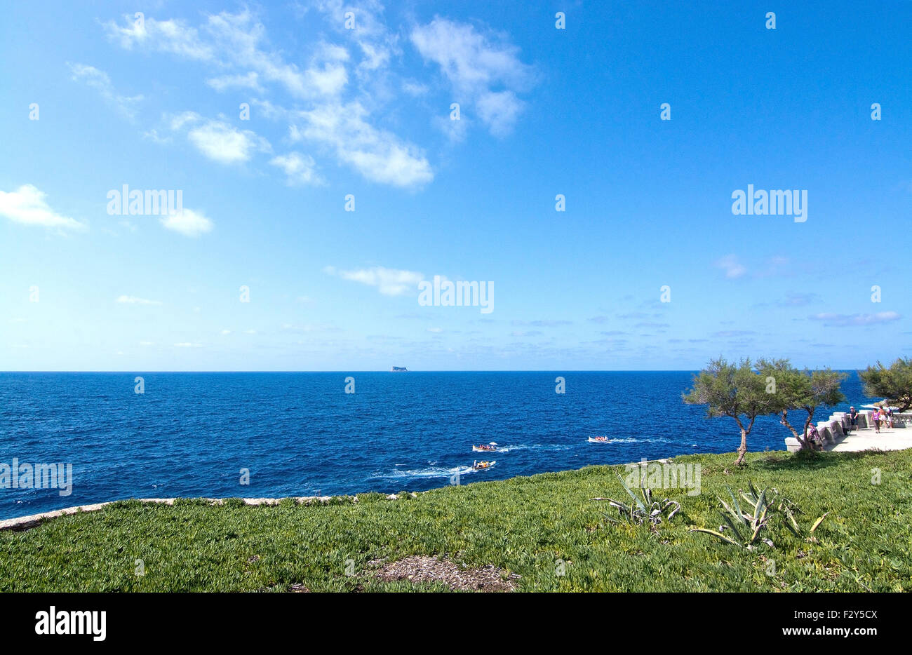 Bird island Filfla on the horizon and boat with people in the water of ...