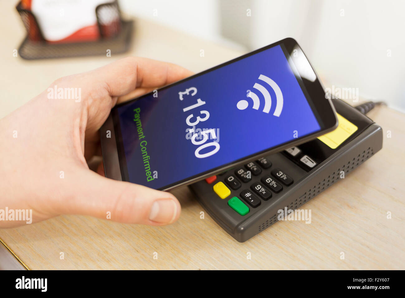 Man paying with NFC technology on mobile phone, Pound version Stock ...