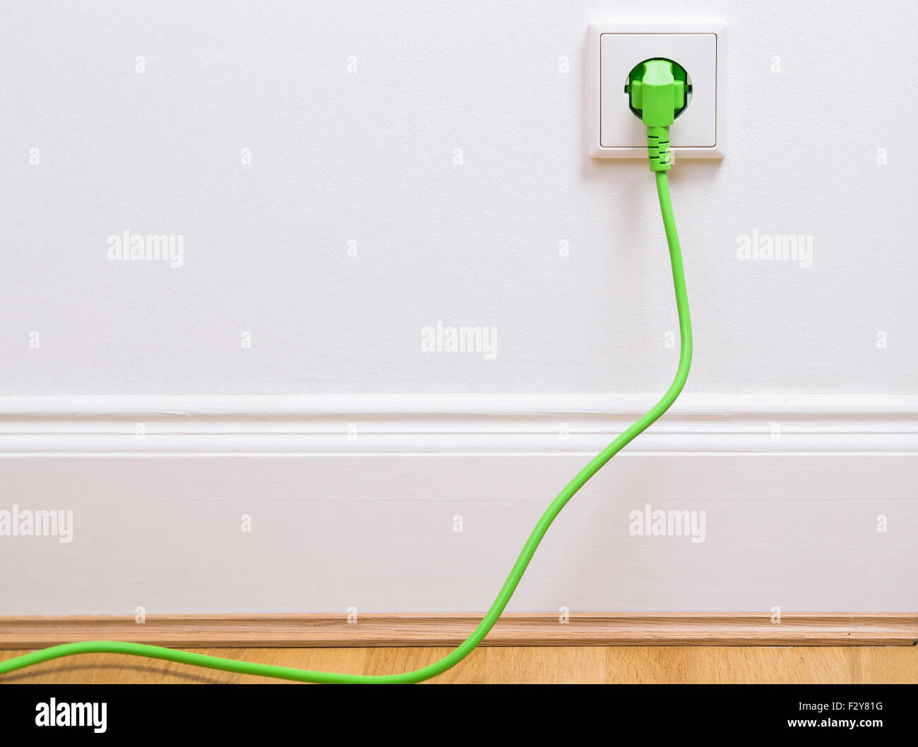 Interior outlet with a green plugged in cable Stock Photo - Alamy