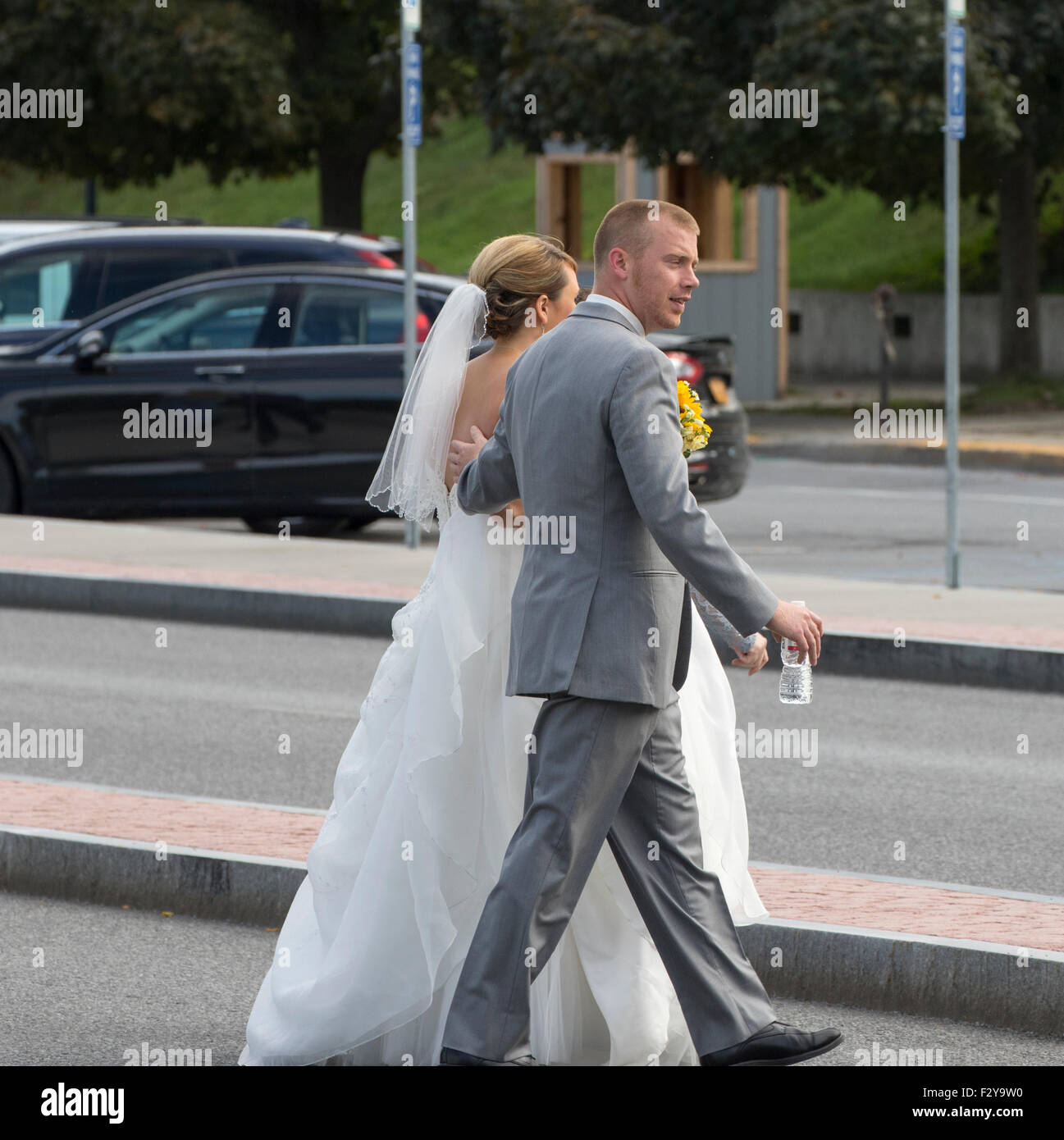 Bride in gown and Groom in tux walking in Lake George New York USA ...