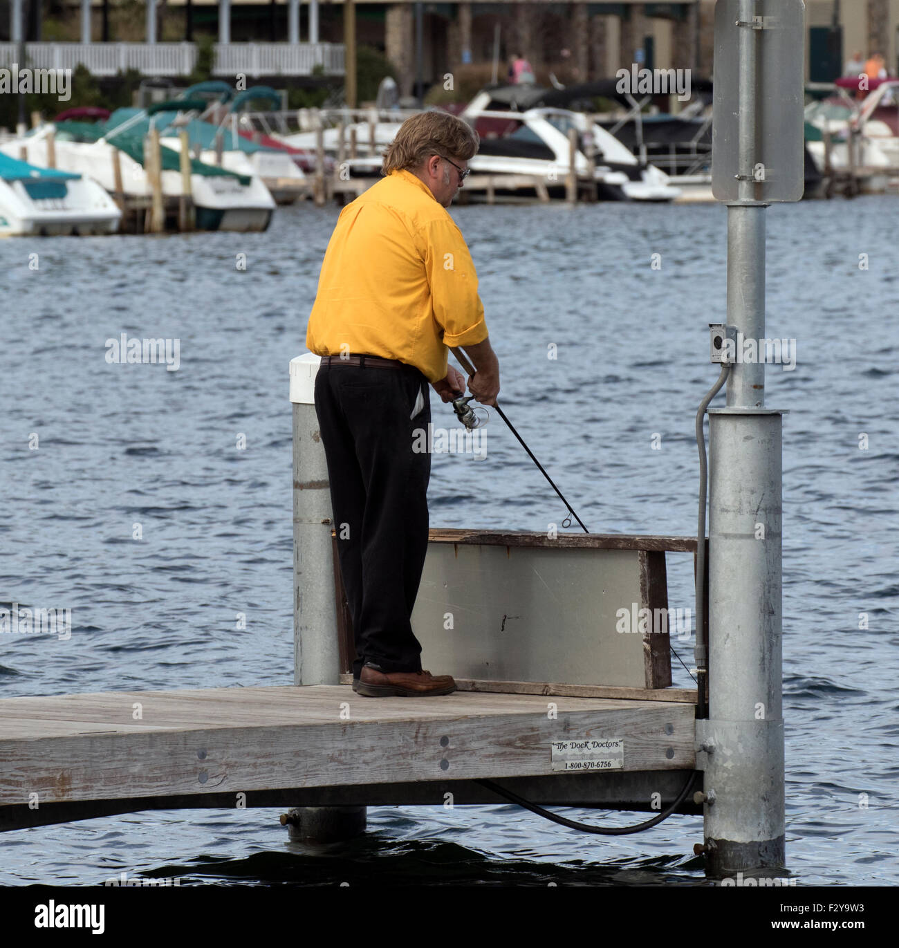 Man fishing off the end of a dock at Lake George New York USA US ...