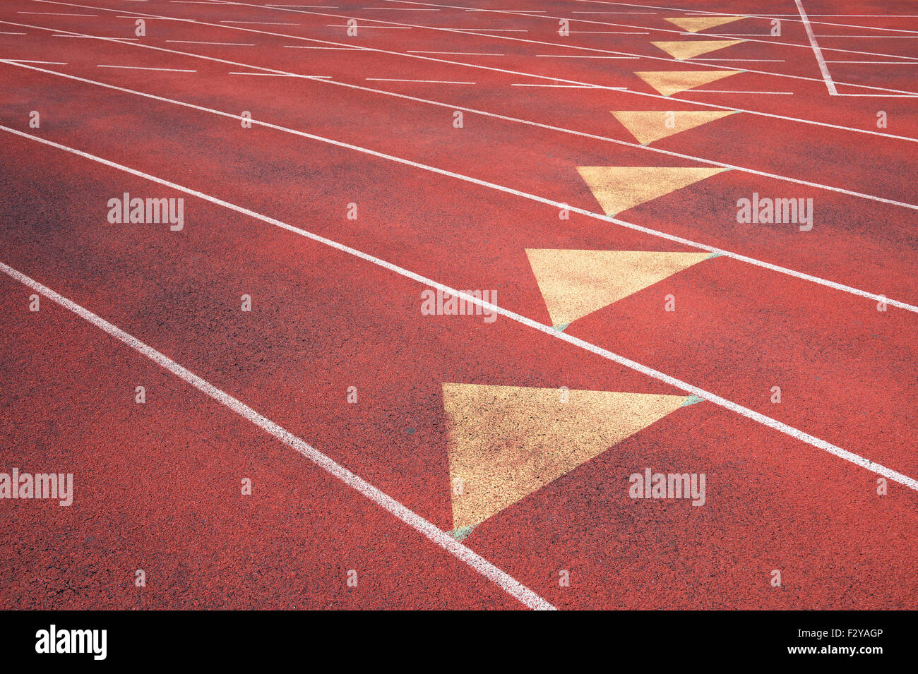 Athletic running track in weathered red rubber close-up with abstract ...