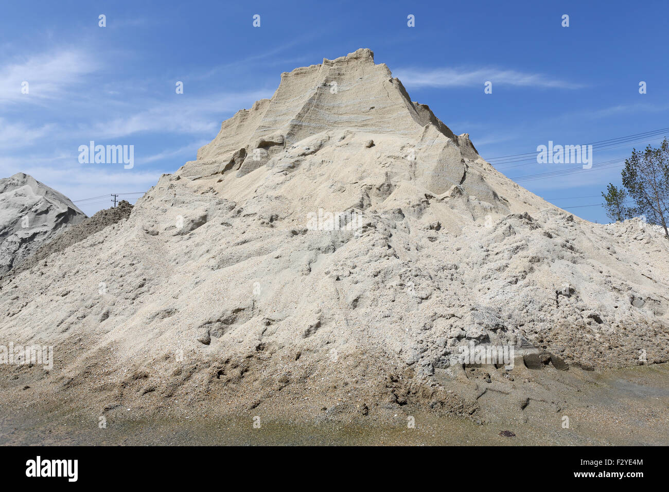 gravel sand mound against a blue sky Stock Photo - Alamy