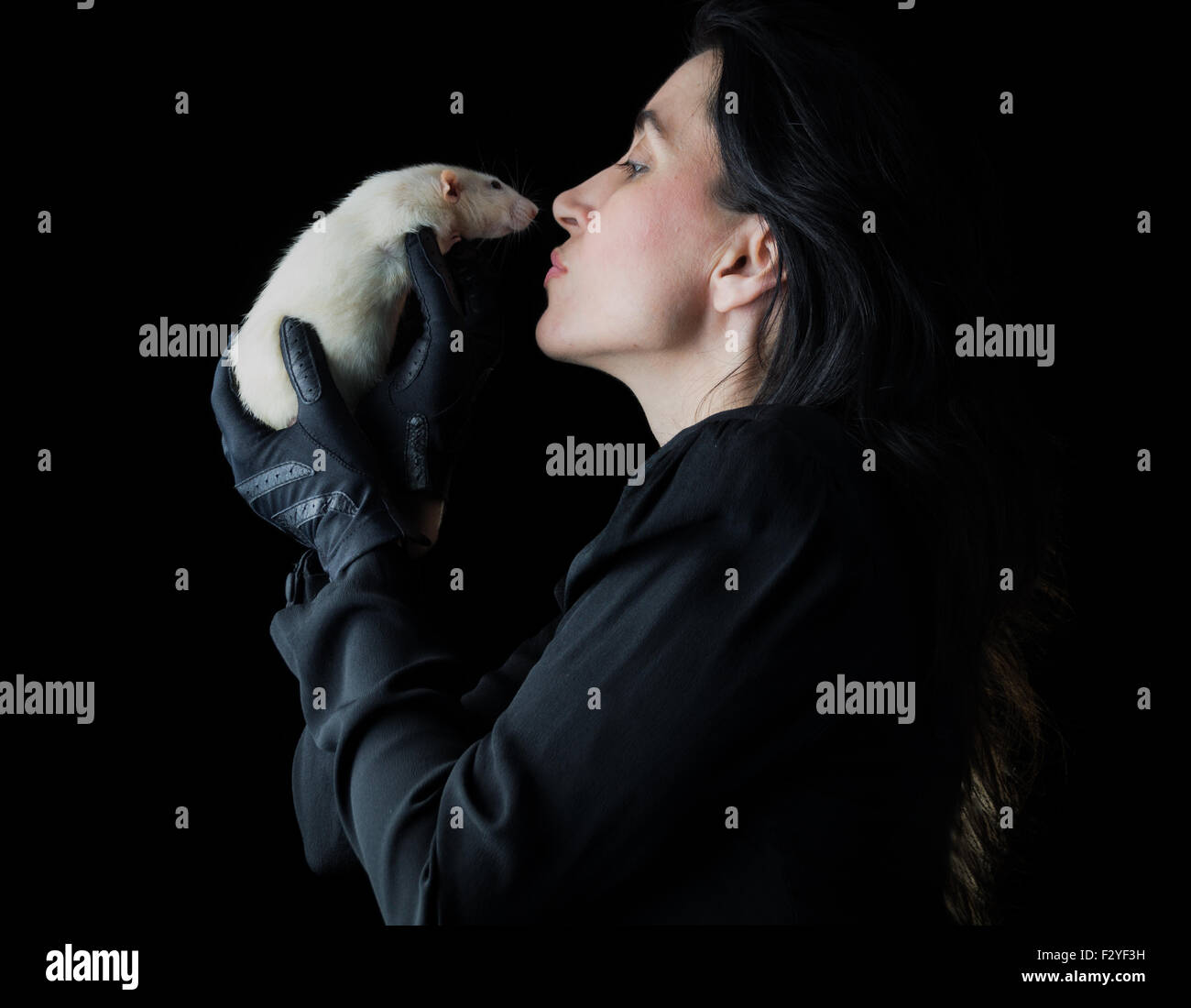 Brunette woman in black holding a white rat Stock Photo - Alamy