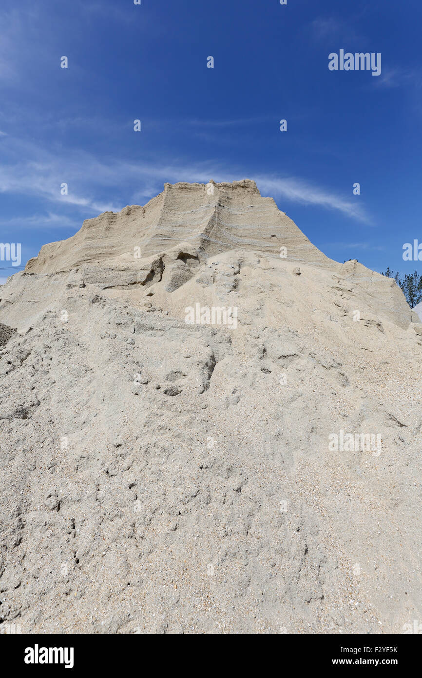 gravel sand mound against a blue sky Stock Photo - Alamy