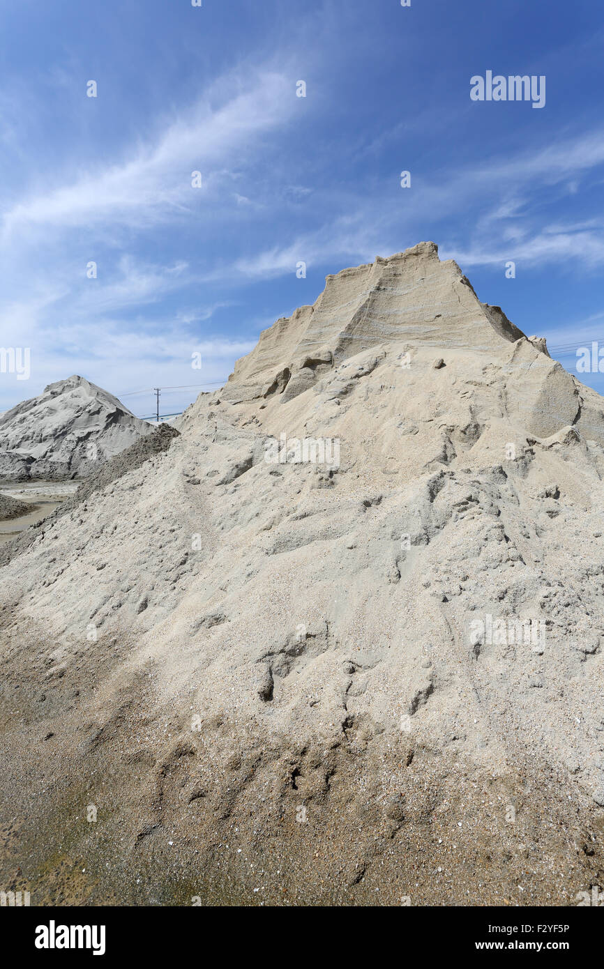 gravel sand mound against a blue sky Stock Photo - Alamy