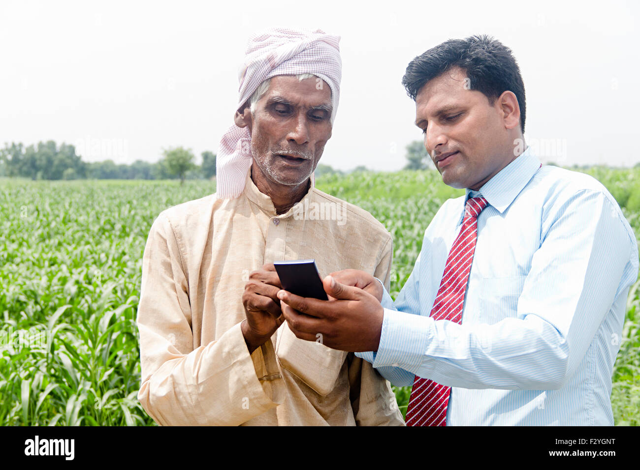 2 indian Business Man and rural farmer farm Mobile Phone Stock Photo ...