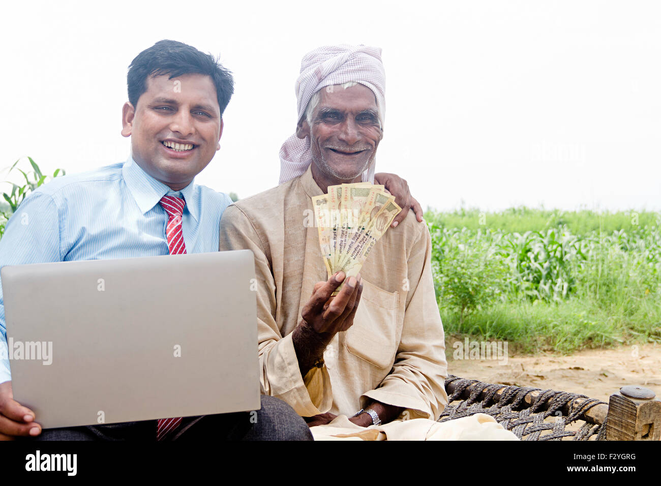 indian rural Business Man and farmer farm laptop and money showing ...