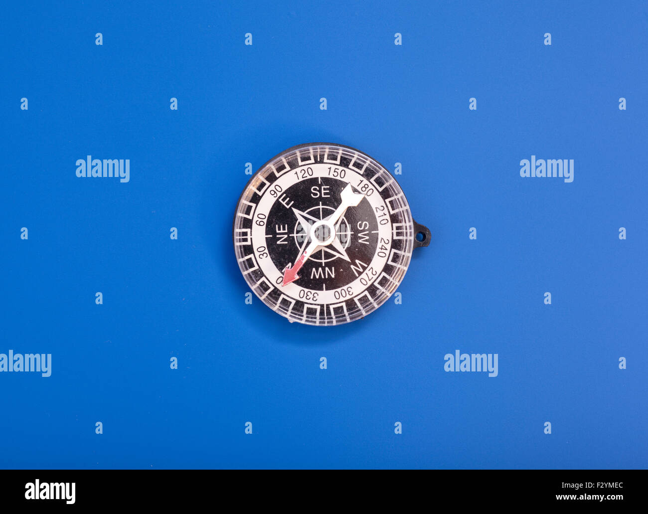 Compass on blue background Stock Photo - Alamy