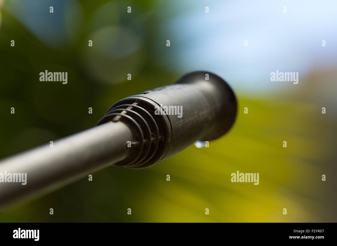 Closeup black head of high pressure water cleaner as waterbeam emerges ...