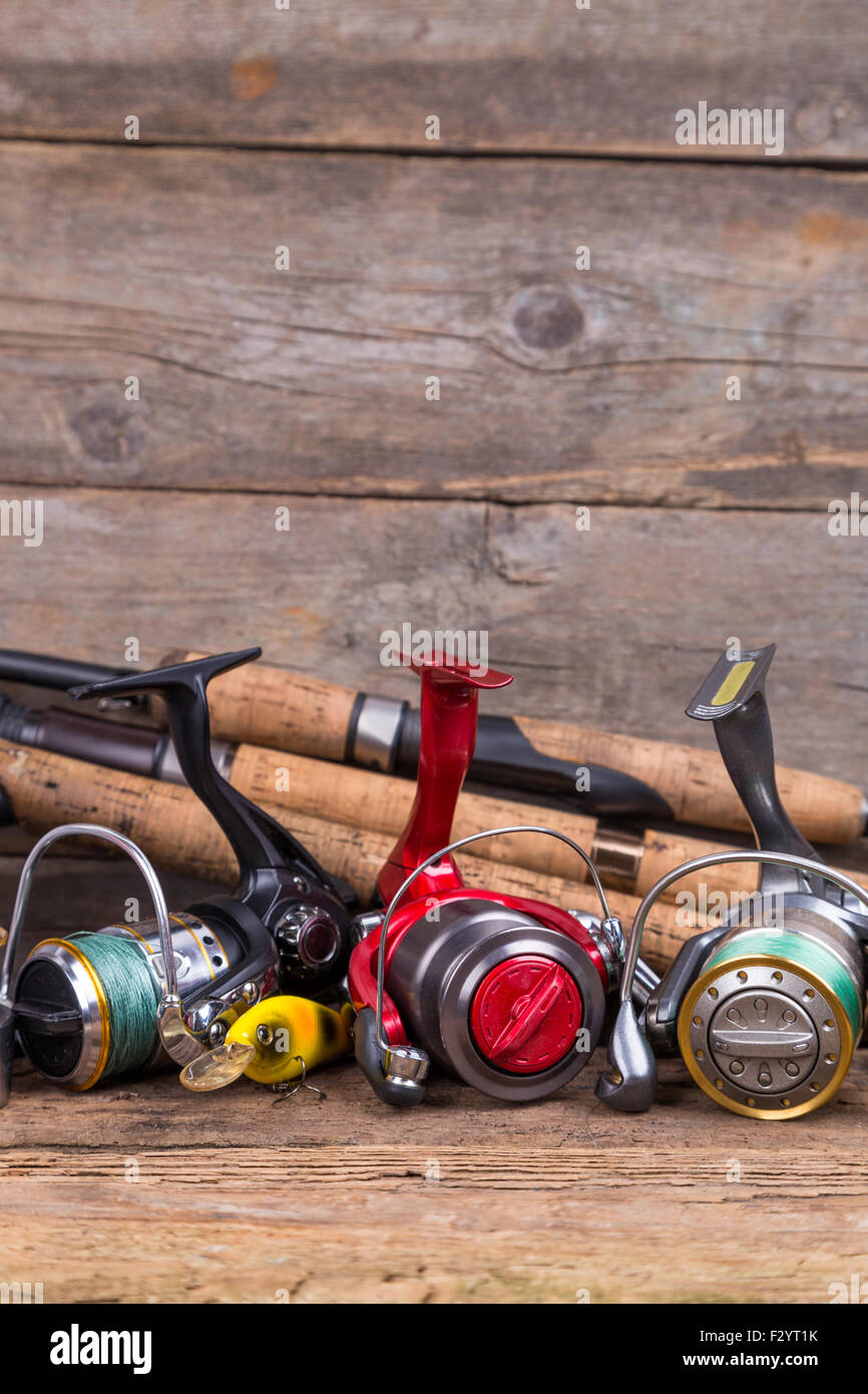 fishing tackles different rod and reel on timber board background. for ...