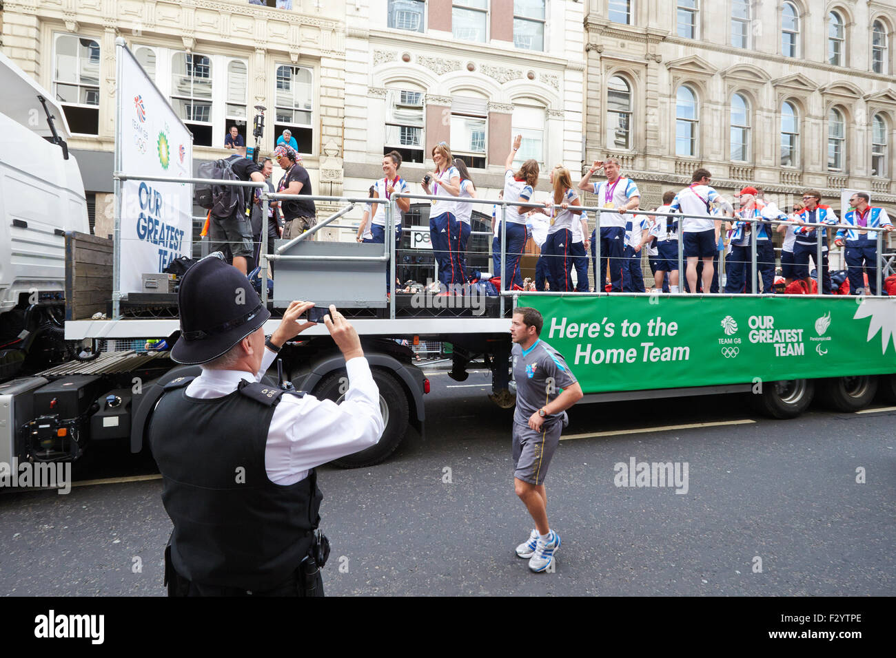 A police officer photographs an athletes float during the Olympic and ...