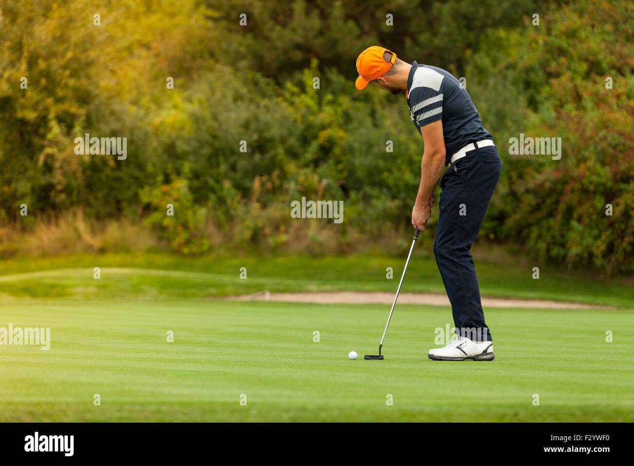 Golf player with club Stock Photo - Alamy