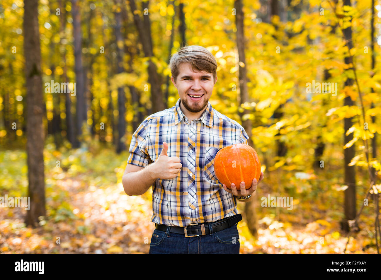 Smiling man carrying pumpkin outdoors Stock Photo - Alamy
