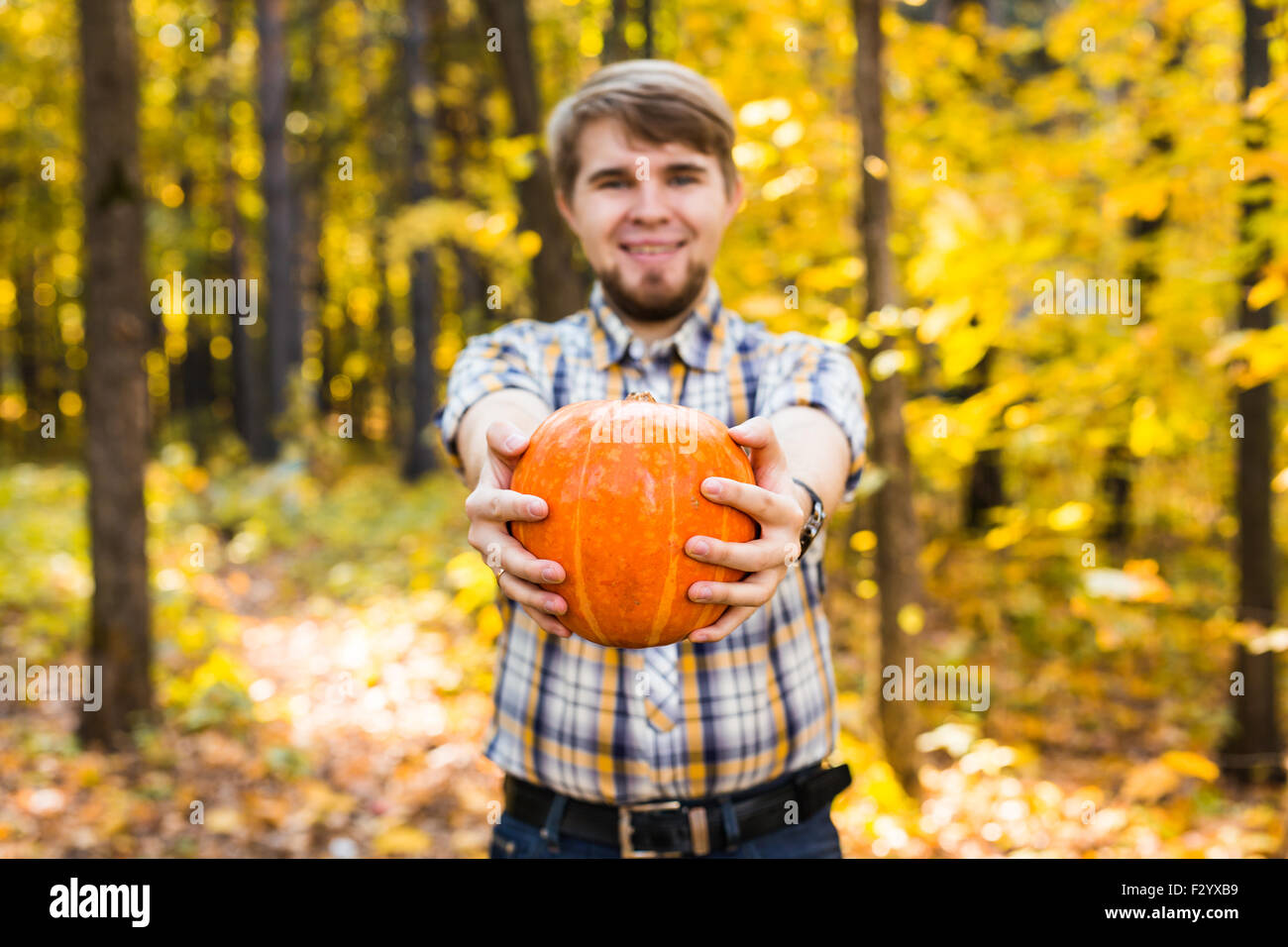 Smiling man carrying pumpkin outdoors Stock Photo - Alamy