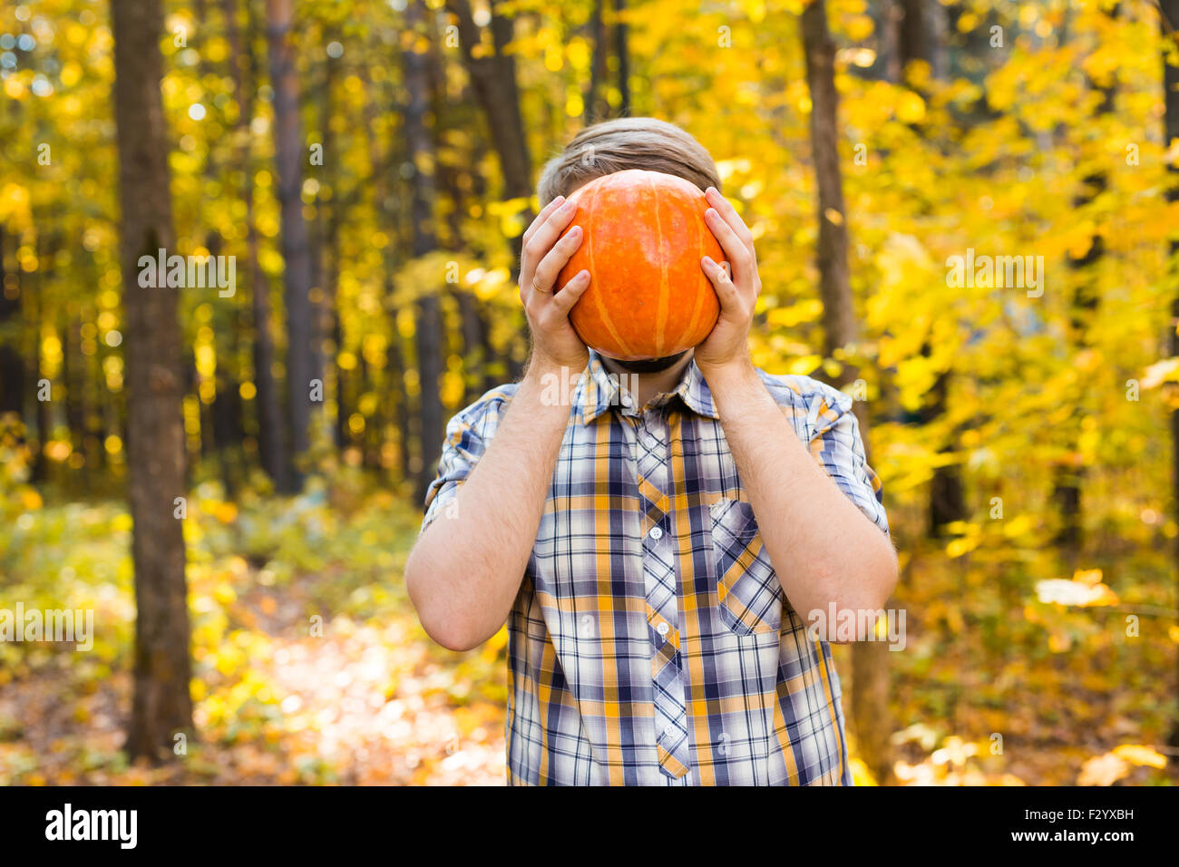 Smiling man carrying pumpkin outdoors Stock Photo - Alamy