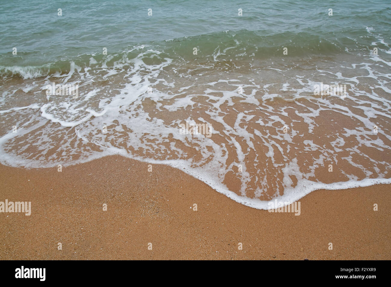 Sea wave over sand Stock Photo - Alamy