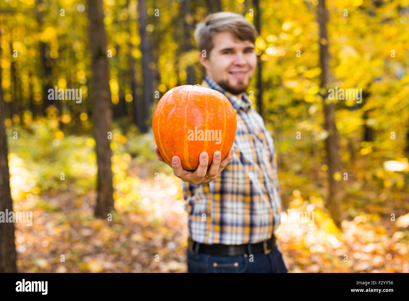 Smiling man carrying pumpkin outdoors Stock Photo - Alamy