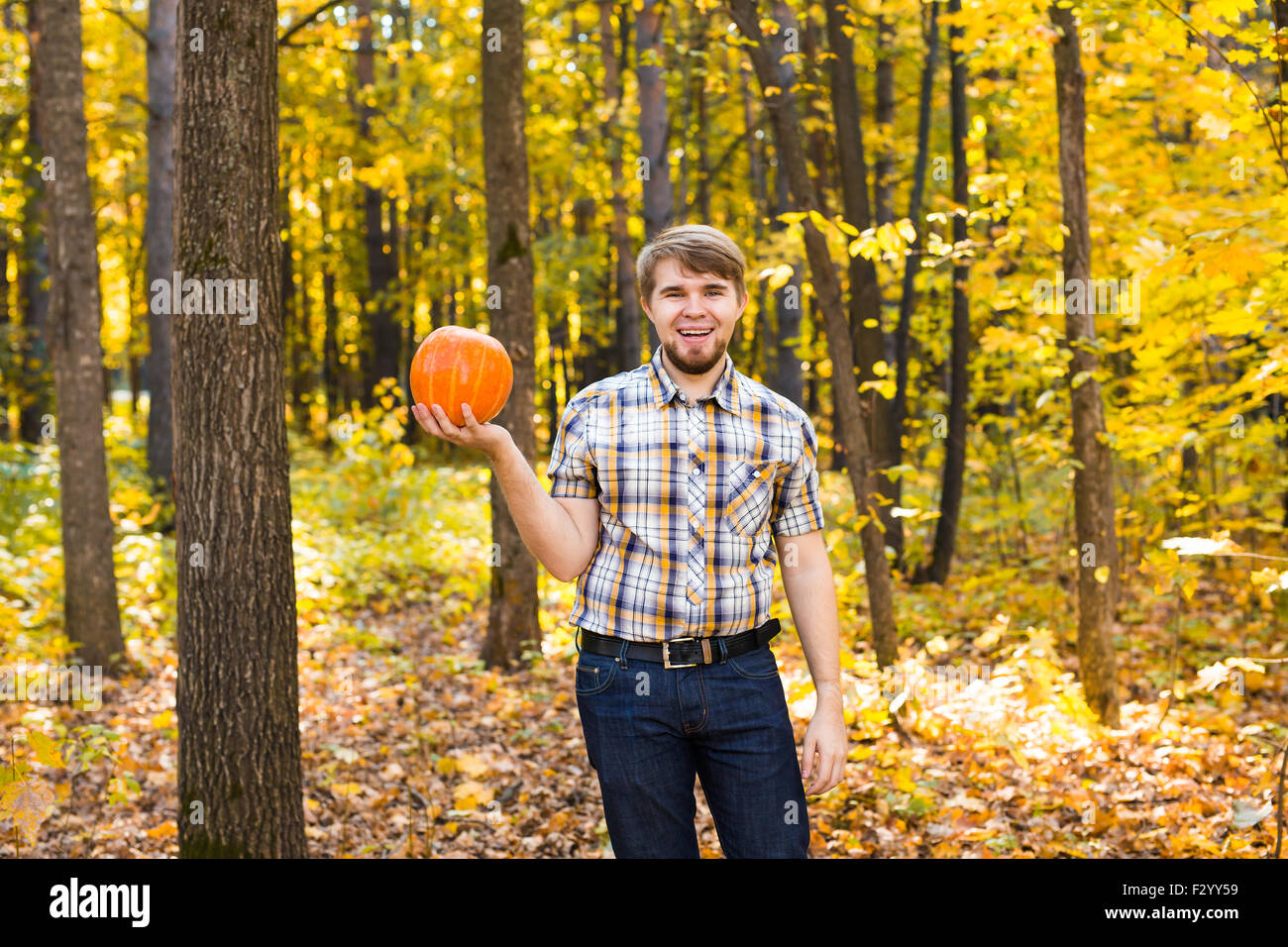 Smiling man carrying pumpkin outdoors Stock Photo - Alamy