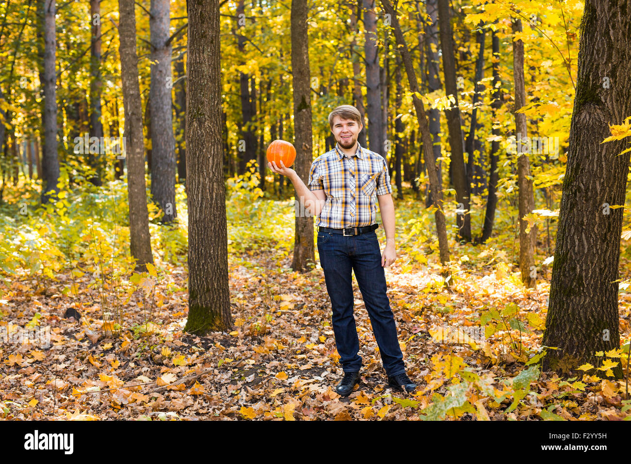 Smiling man carrying pumpkin outdoors Stock Photo - Alamy