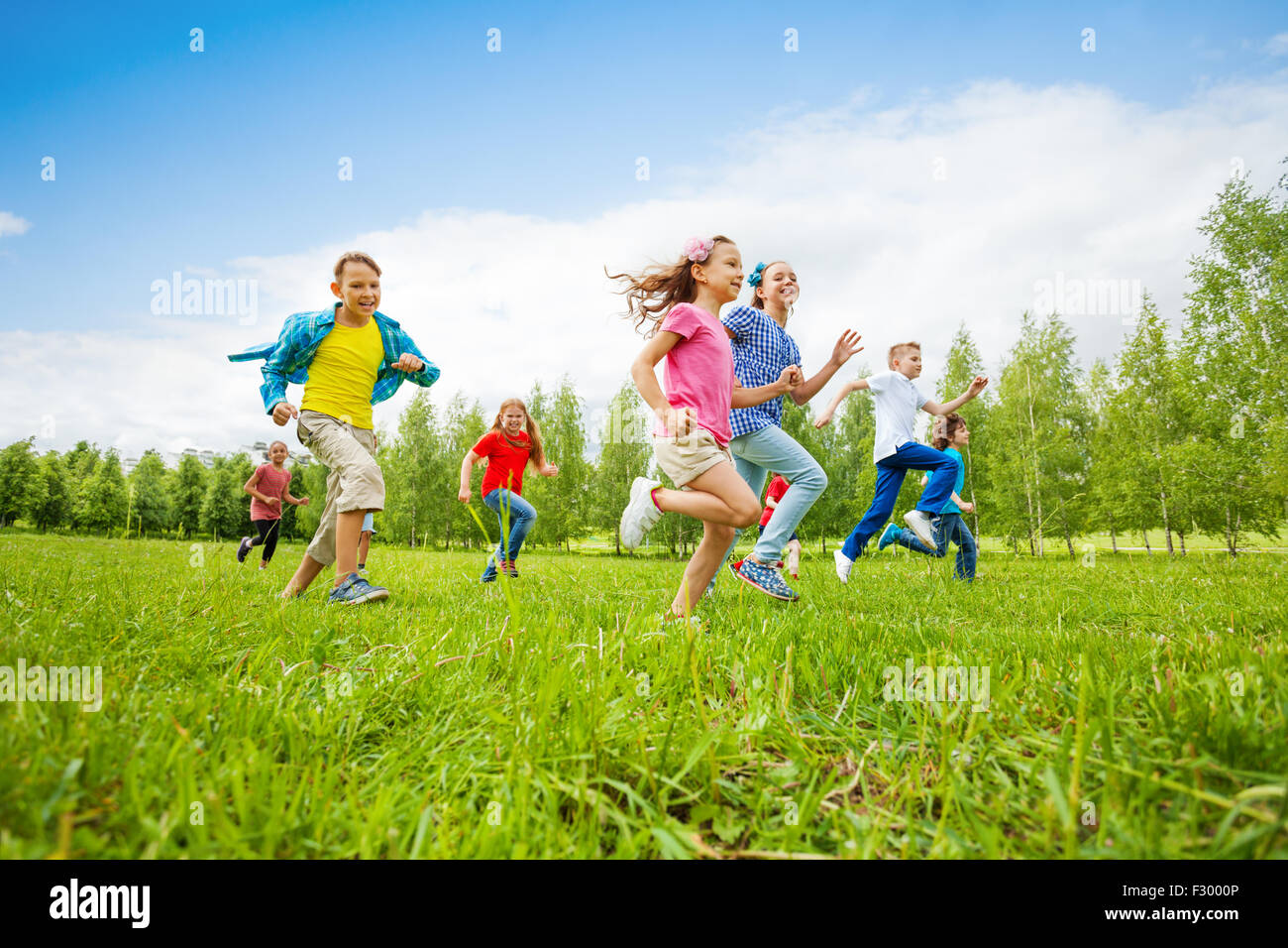 Children are running through green field together Stock Photo - Alamy