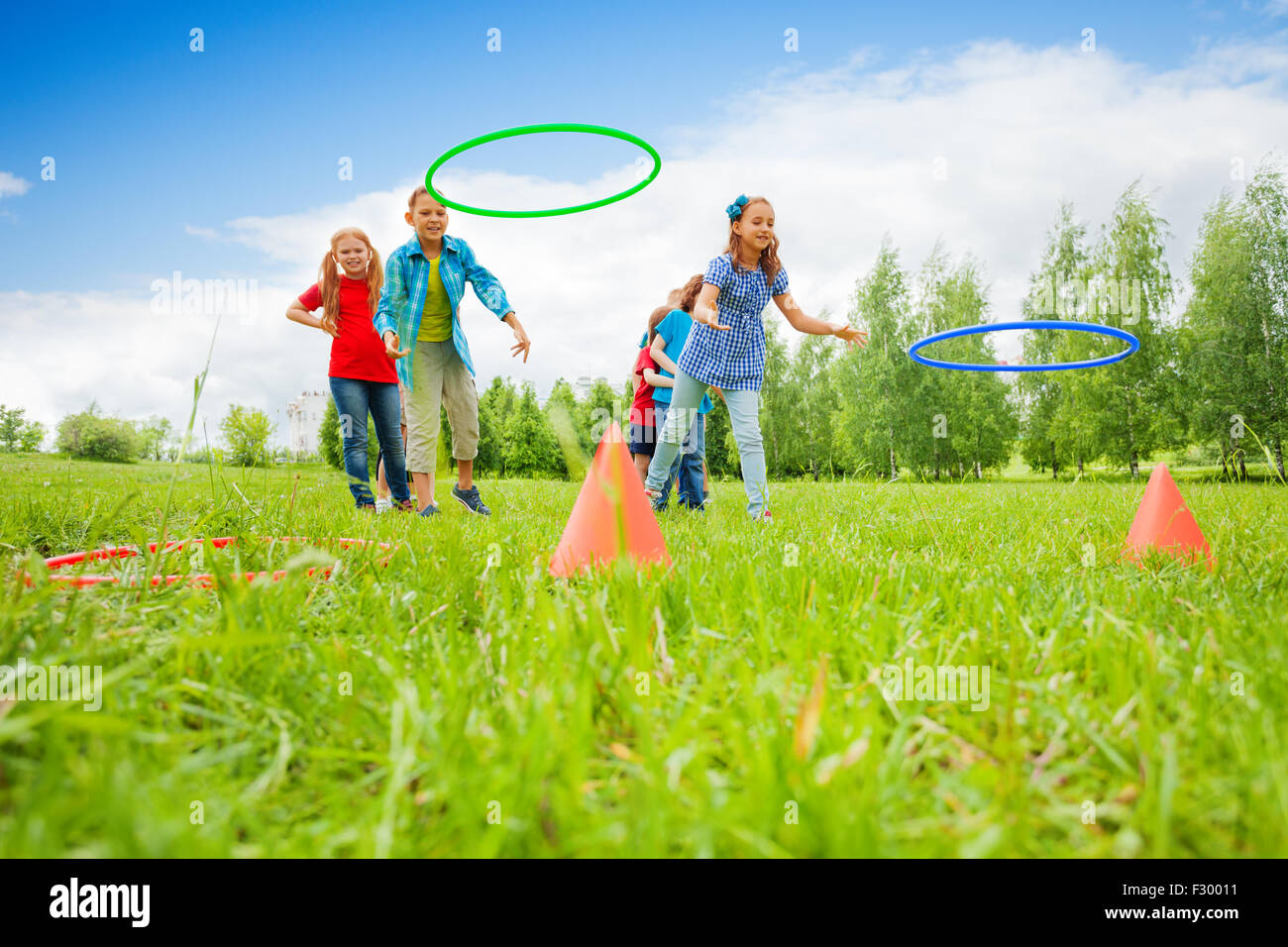Two group of kids play throwing colorful hoops Stock Photo - Alamy