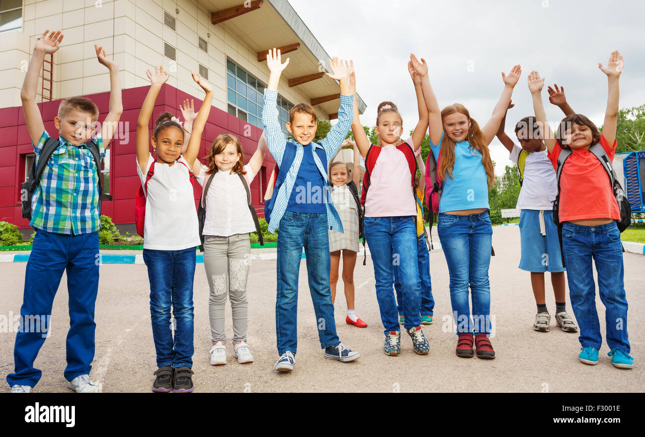 Happy children with arms up standing near school Stock Photo - Alamy