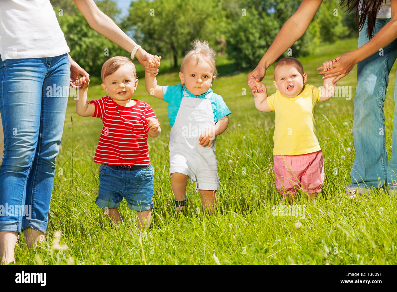 Happy toddlers learn to walk holding mothers hands Stock Photo - Alamy