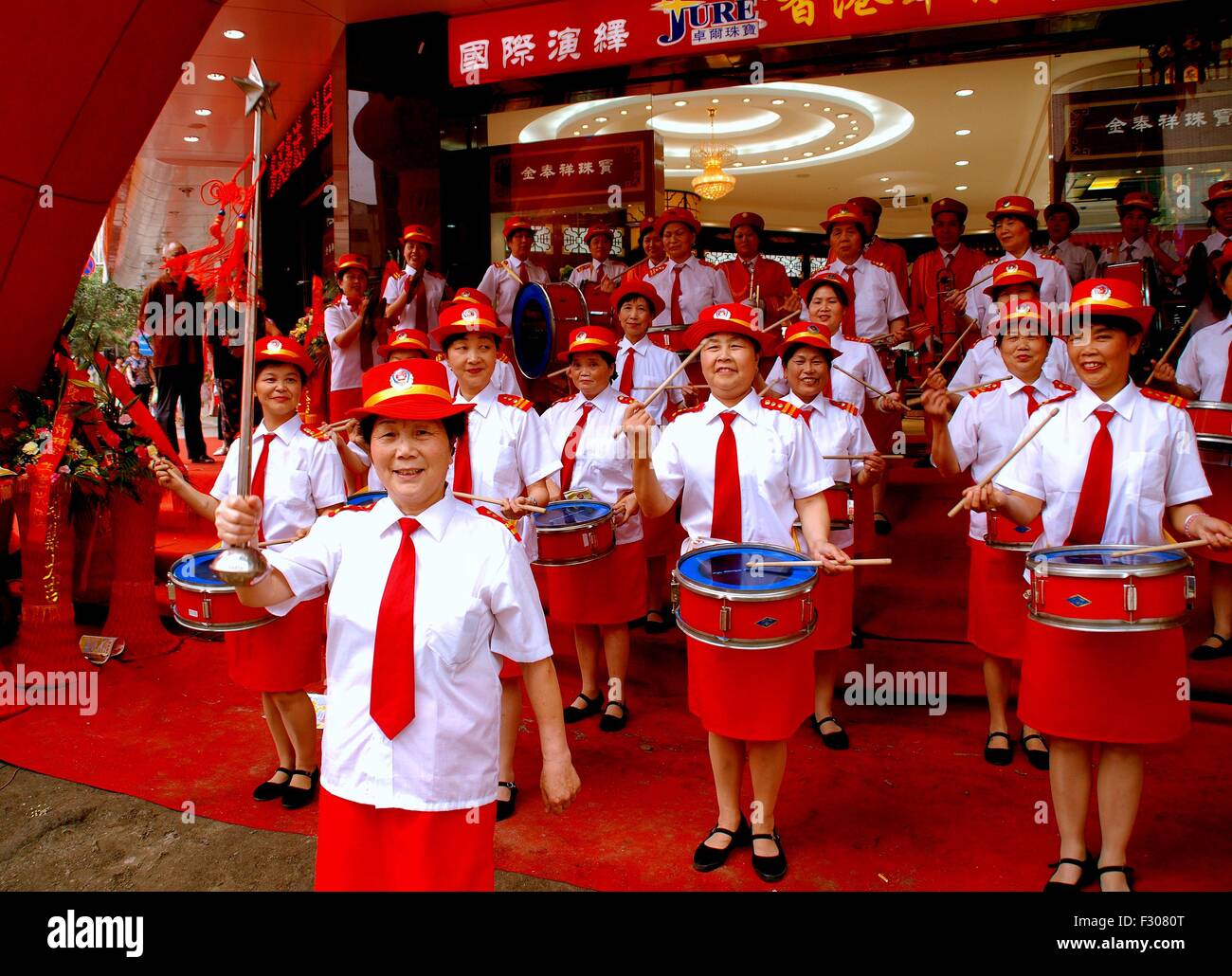 Pengzhou, China: A women's waist drum marching band and its leader with ...
