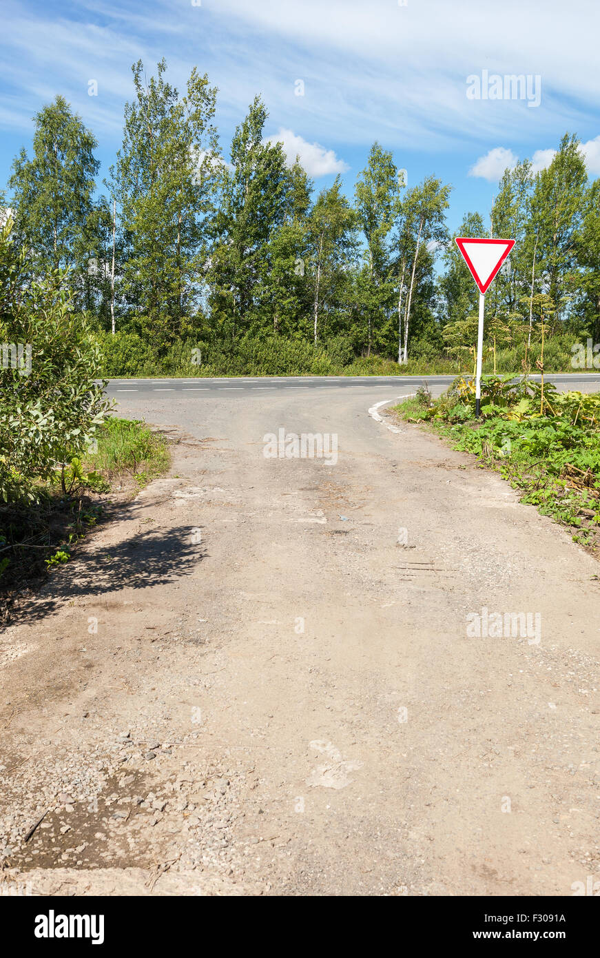 Asphalt highway with the slip road and traffic sign give way. Sunny day ...
