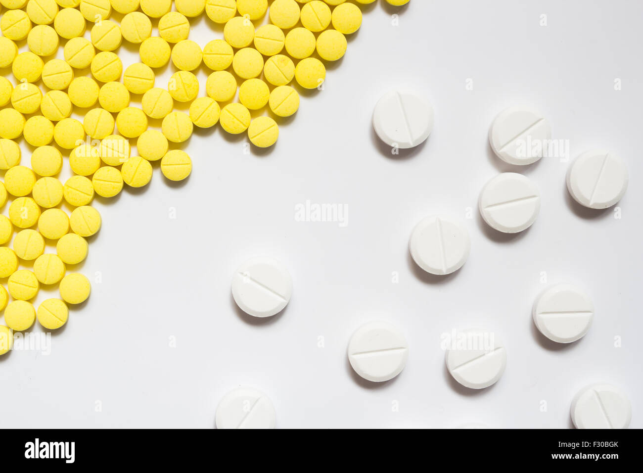 Yellow and white pills on white background with shadow Stock Photo - Alamy