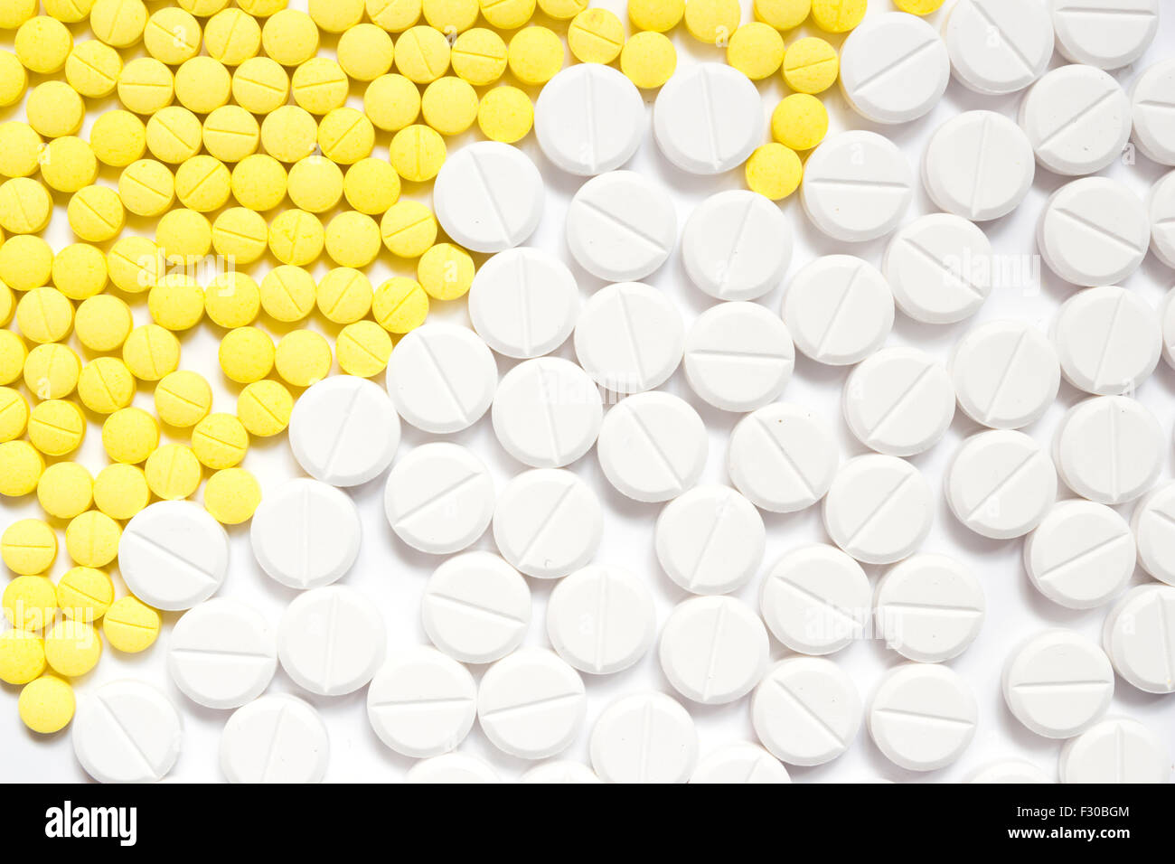 Yellow and white pills on white background with shadow Stock Photo - Alamy