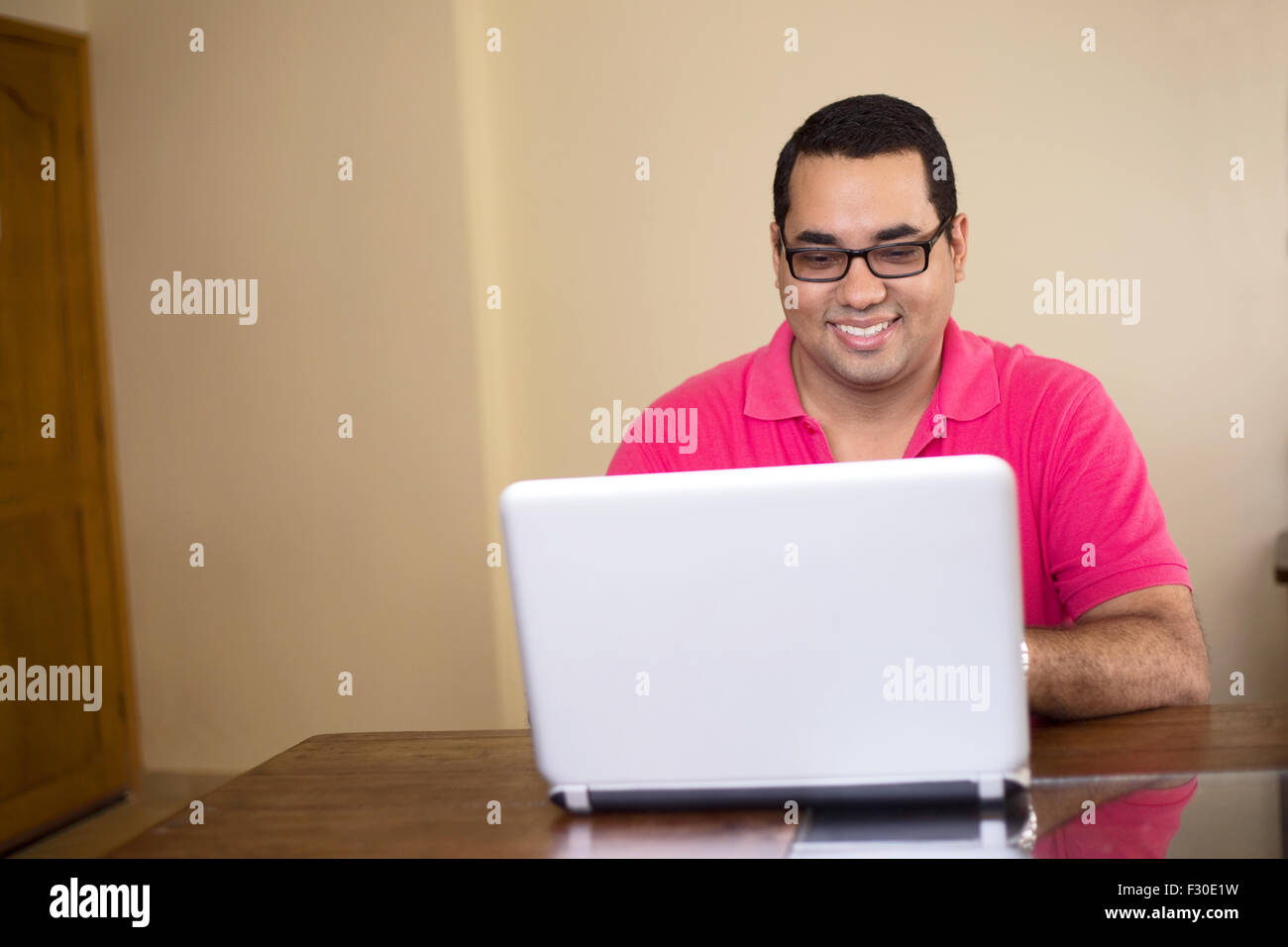 happy young latino man working on a computer Stock Photo - Alamy