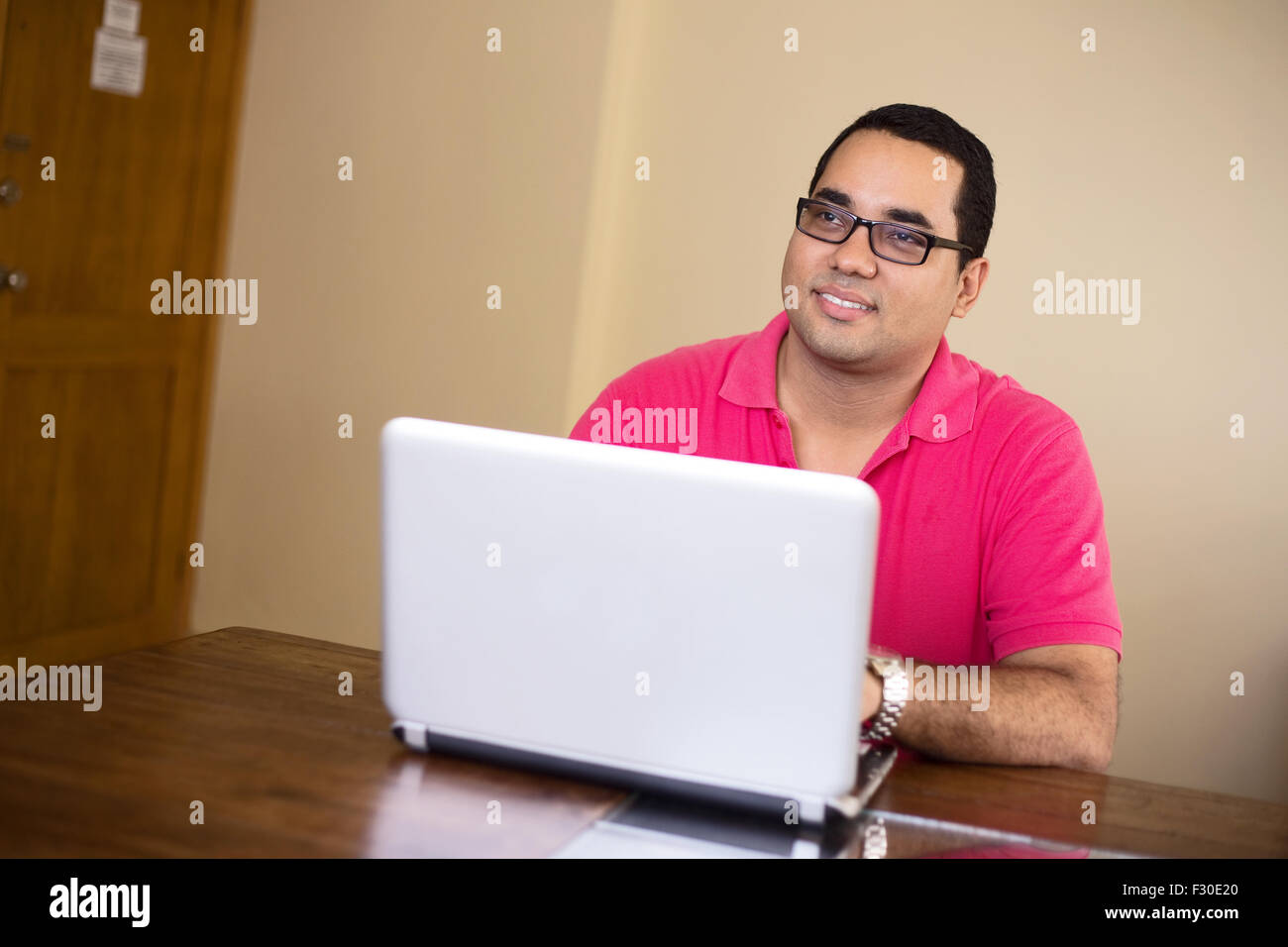 young man working on a computer looking thoughtful Stock Photo - Alamy