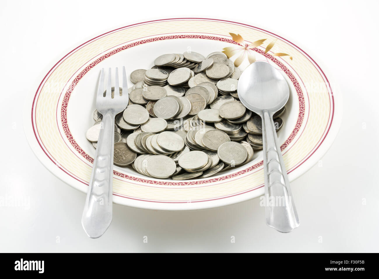 Money on dish with spoon and fork on white background Stock Photo - Alamy