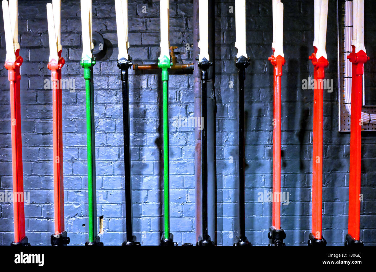 Railway junction change levers against deep blue brick wall, Red, green ...