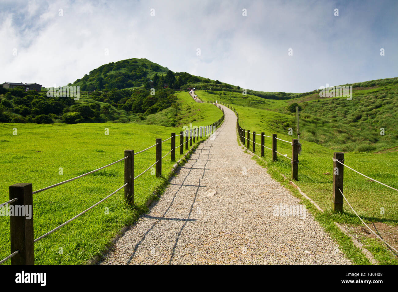 gravel path in green mountain against blue cloudy sky Stock Photo - Alamy
