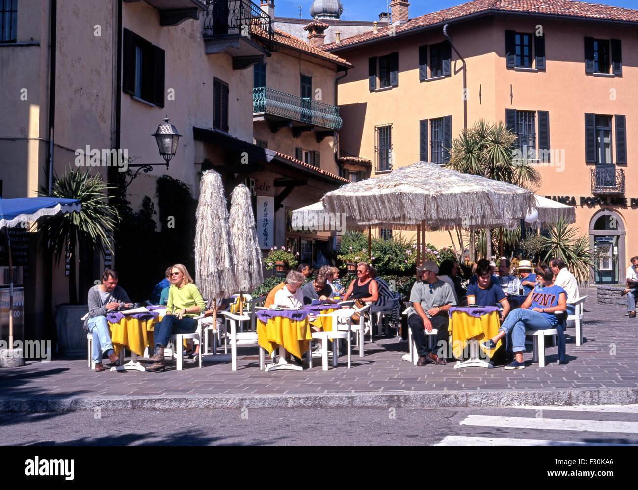 Tourists relaxing at a pavement cafe in main town square, Menaggio ...