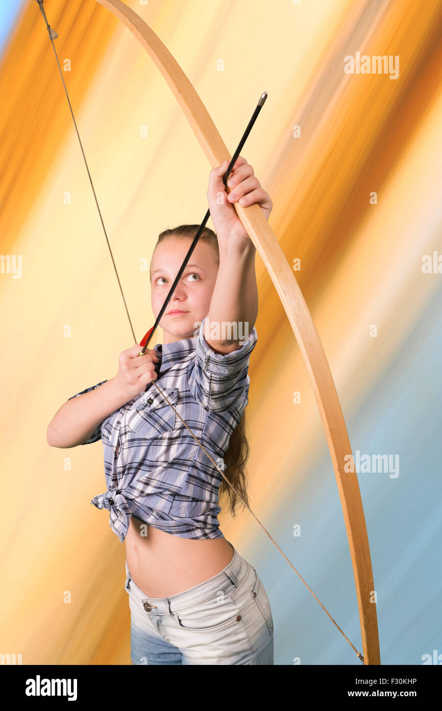 Teen girl practicing archery standing on abstract background Stock ...