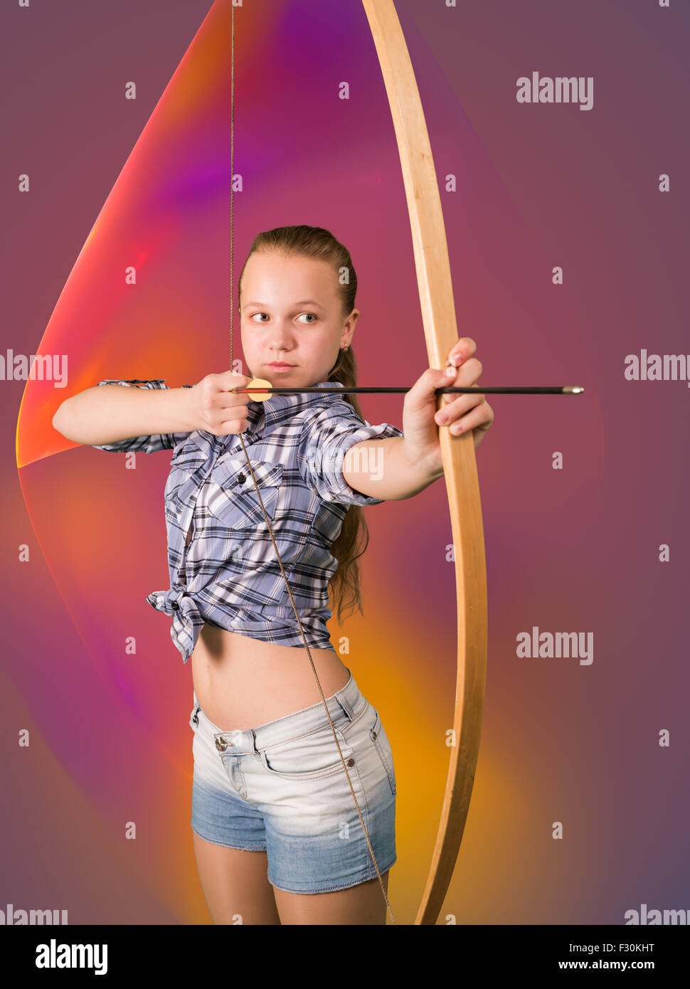 Teen girl practicing archery standing on abstract background Stock ...