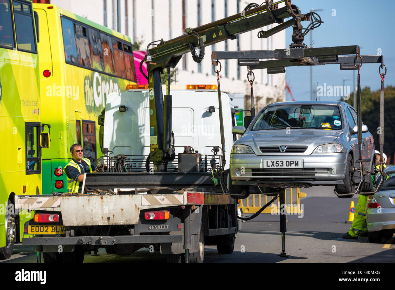 A Car being lifted and taken away on the back of a pickup truck for ...