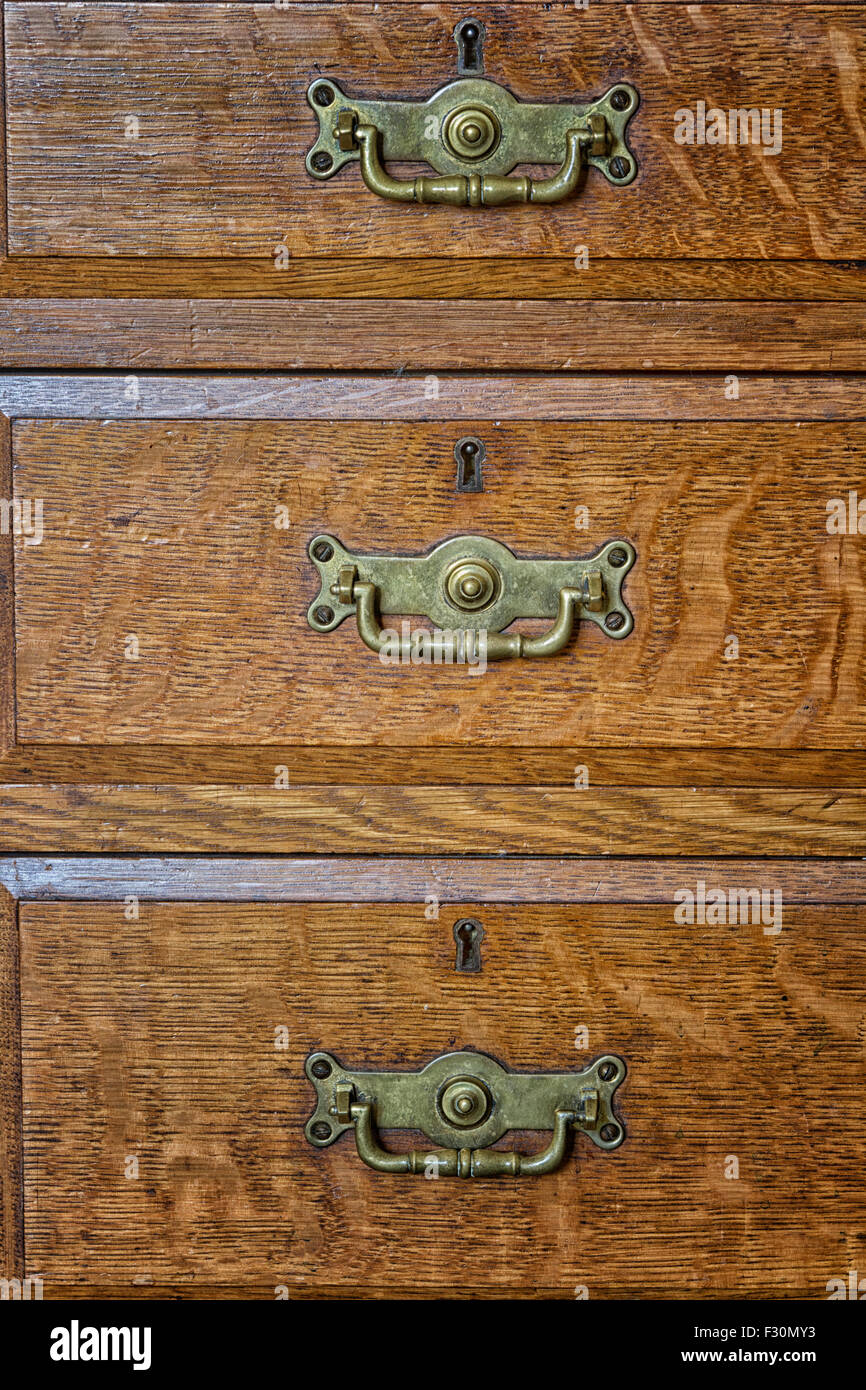 Side draws with brass handles on an antique wooden desk Stock Photo - Alamy