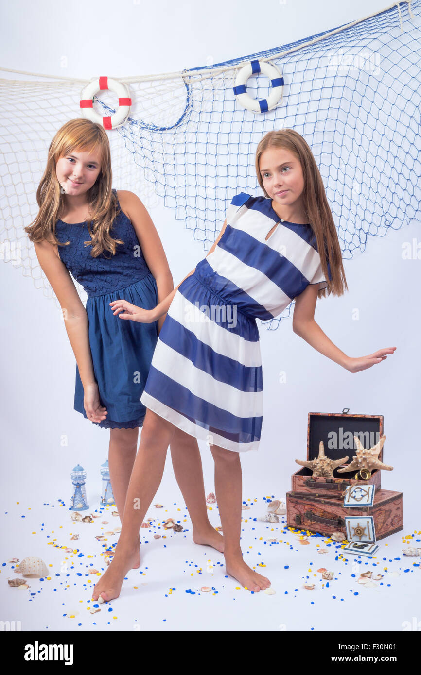 Two beautiful teen girls looking forward and fishing net with lifebuoys ...