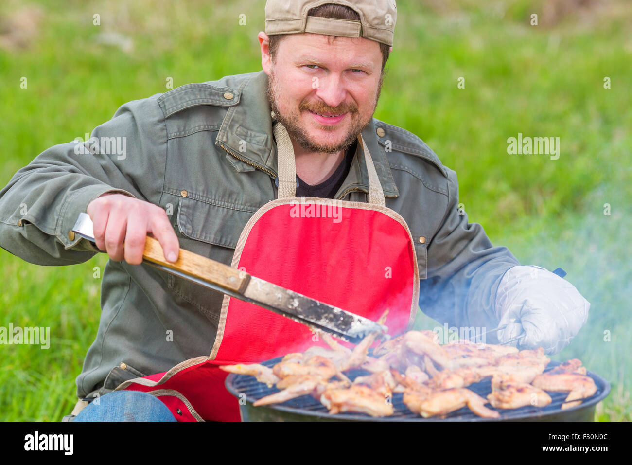 Man preparing barbecue on the lawn chef Stock Photo - Alamy