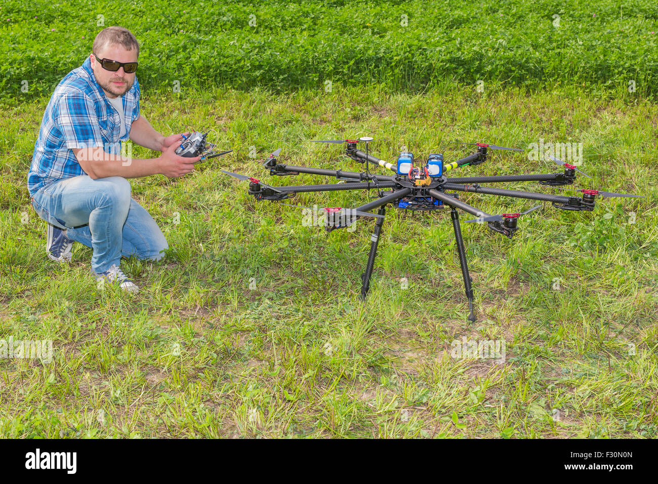 Man with remote control and multicopter on ground Stock Photo - Alamy