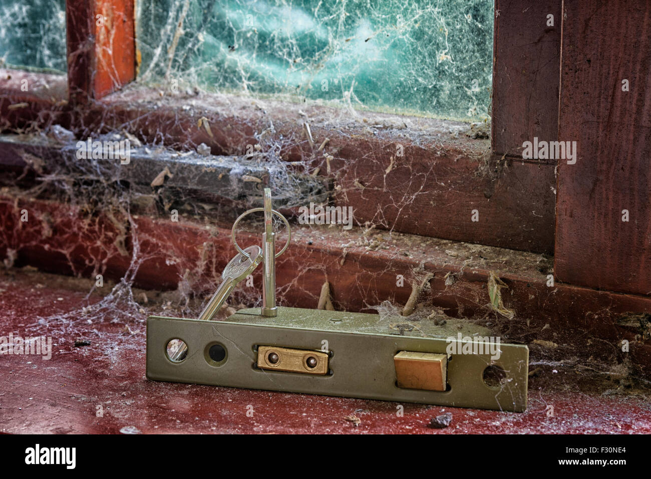 Door locking mechanism with keys on a window ledge covered in cobwebs ...